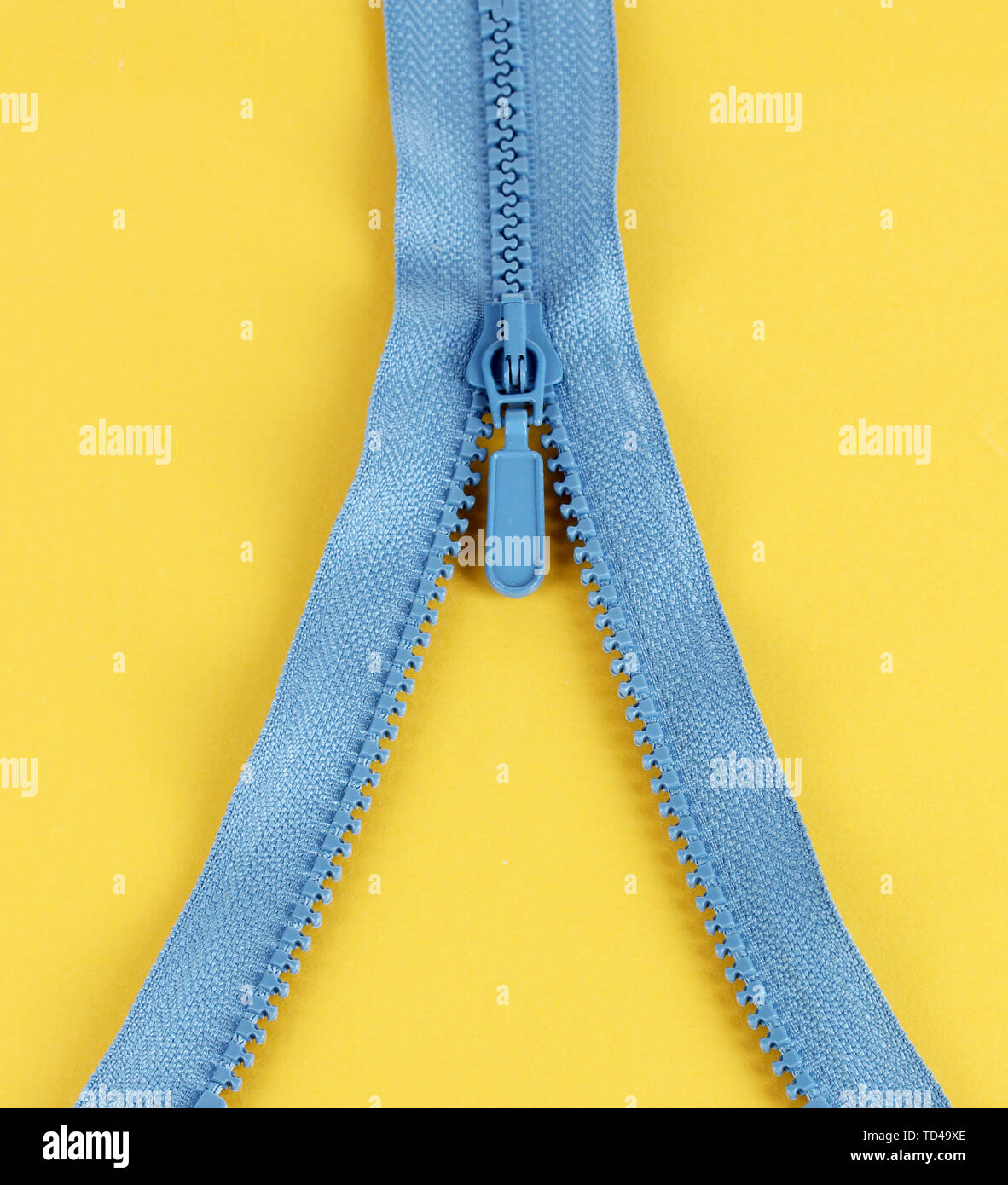 Zipper on yellow background Stock Photo - Alamy