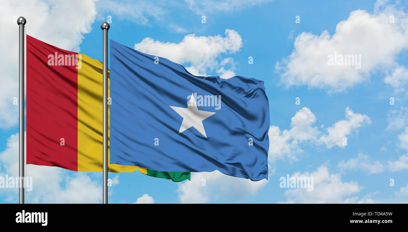 Guinea and Somalia flag waving in the wind against white cloudy blue ...