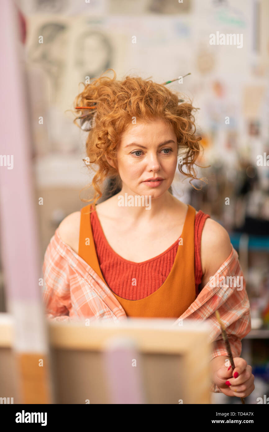 Beautiful artist. Beautiful creative artist with cool hairstyle holding ...