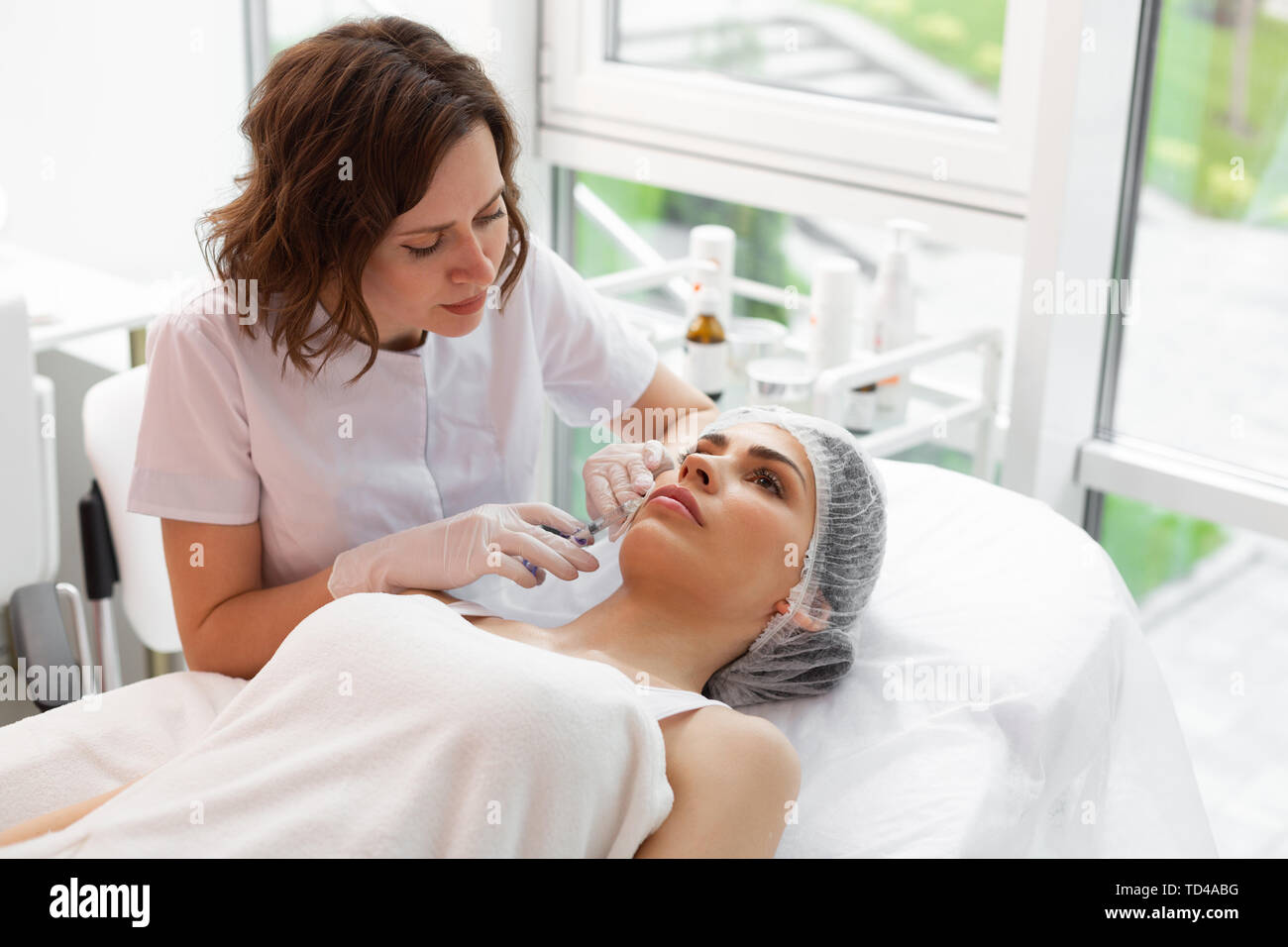 Cosmetology clinic. Nice professional doctor looking at her patients ...