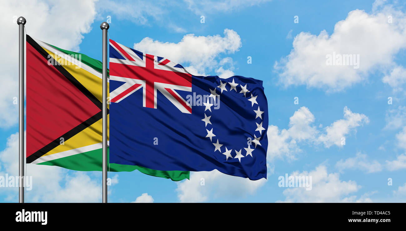 Guyana and Cook Islands flag waving in the wind against white cloudy ...