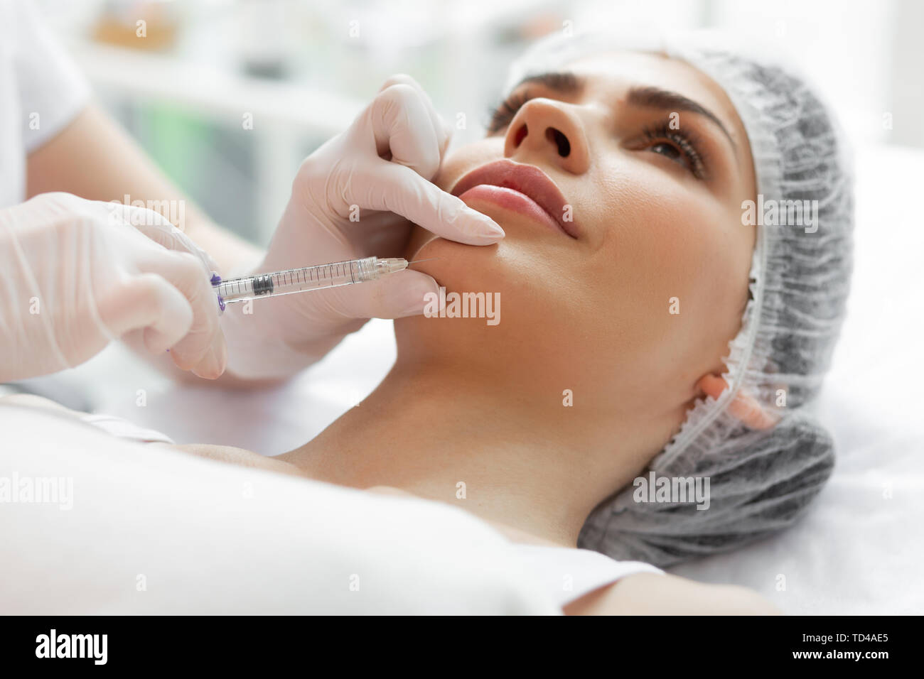 Chin injection. Close up of a female face during the injection in the ...