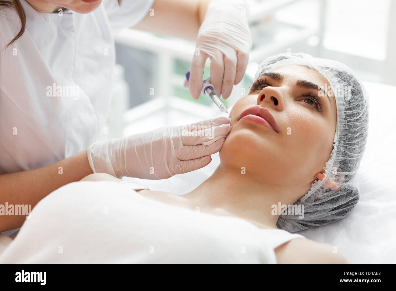 In the cosmetology clinic. Nice good looking woman receiving botox ...