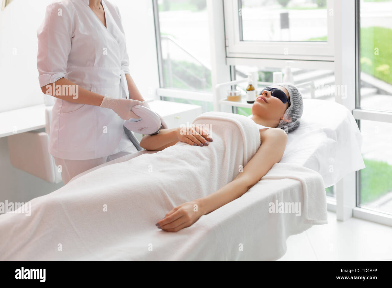 Arms epilation. Pleasant nice woman lying on the medical bed while ...