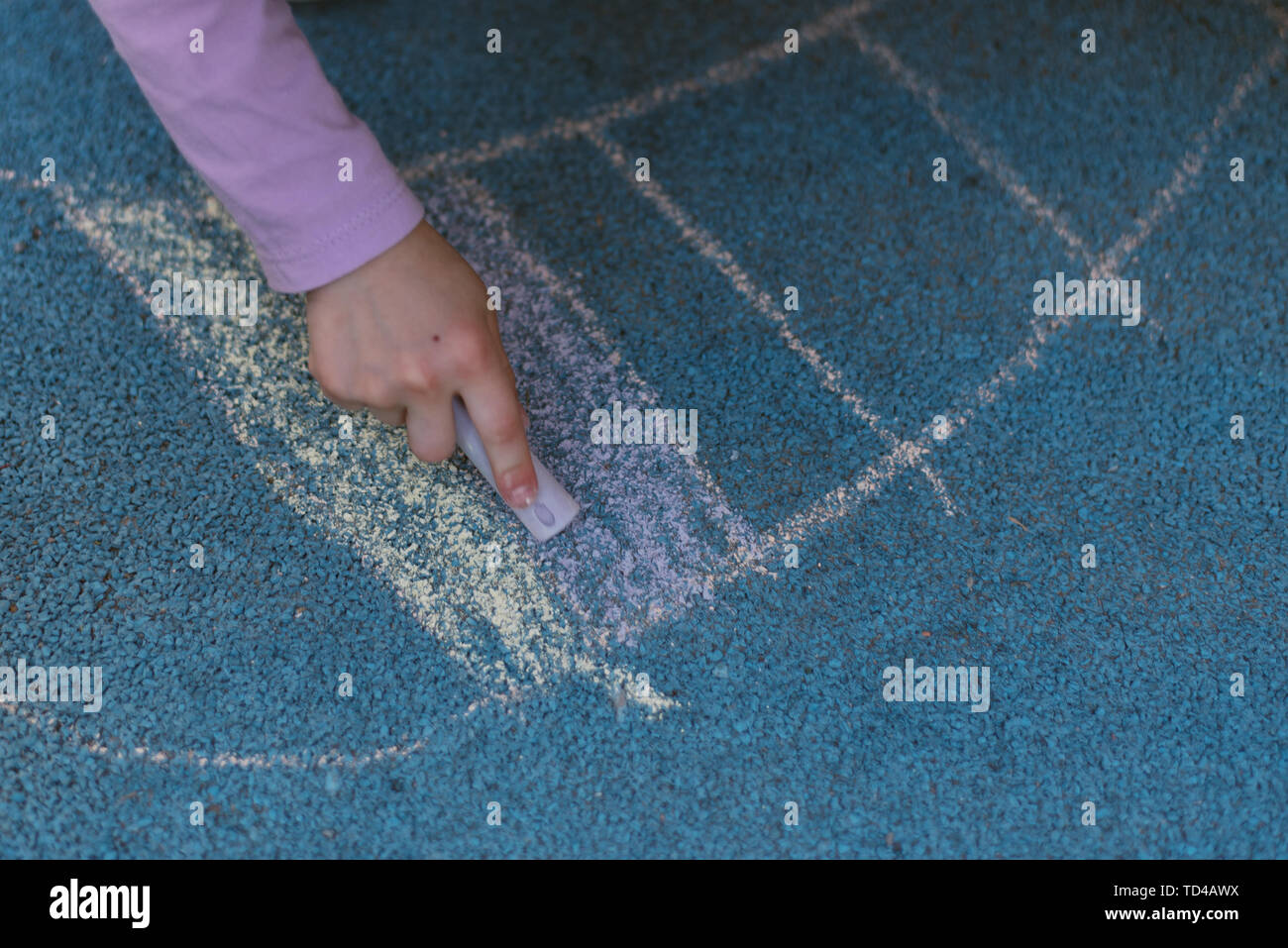 child draws with chalk on the street. Special coating for drawing on ...