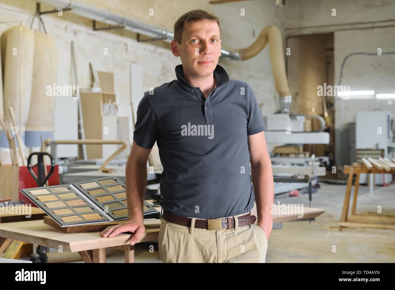 Portrait of smiling male owner of industrial small business woodworking ...