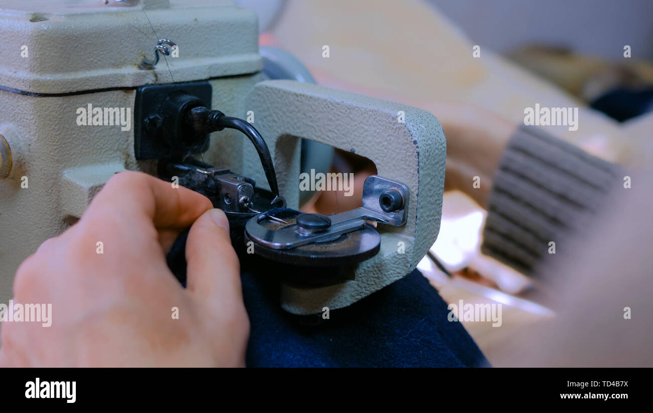 Skinner using sewing machine for stitching fur skin at atelier Stock ...