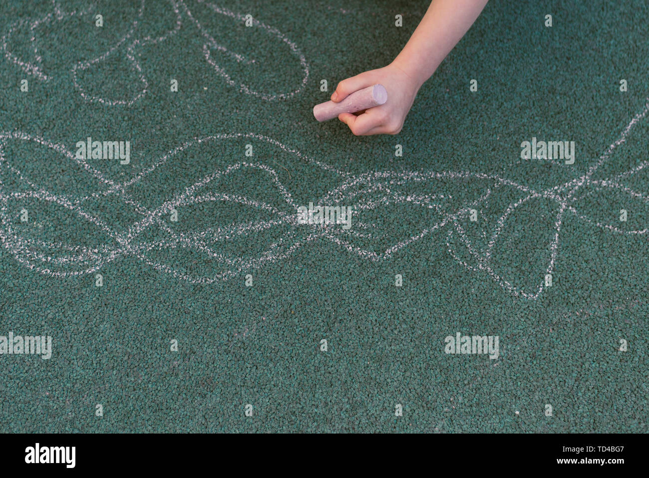 child draws with chalk on the street. Special coating for drawing on ...