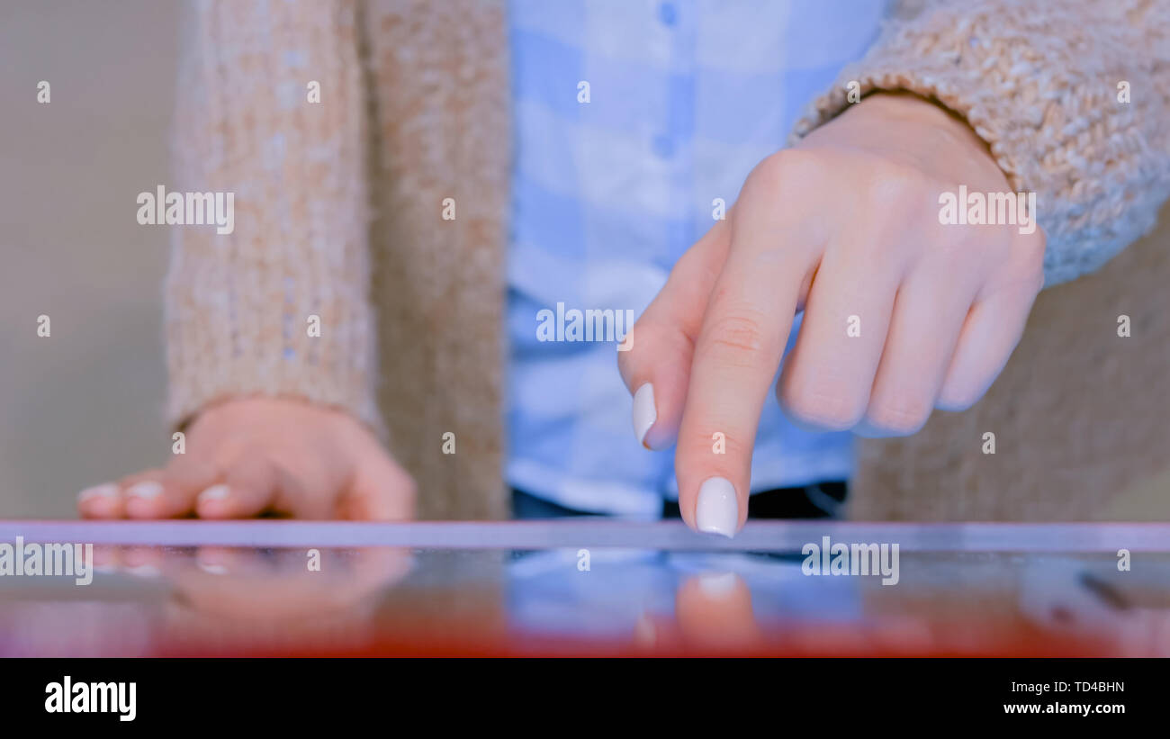 Woman using interactive touchscreen display at technology exhibition ...