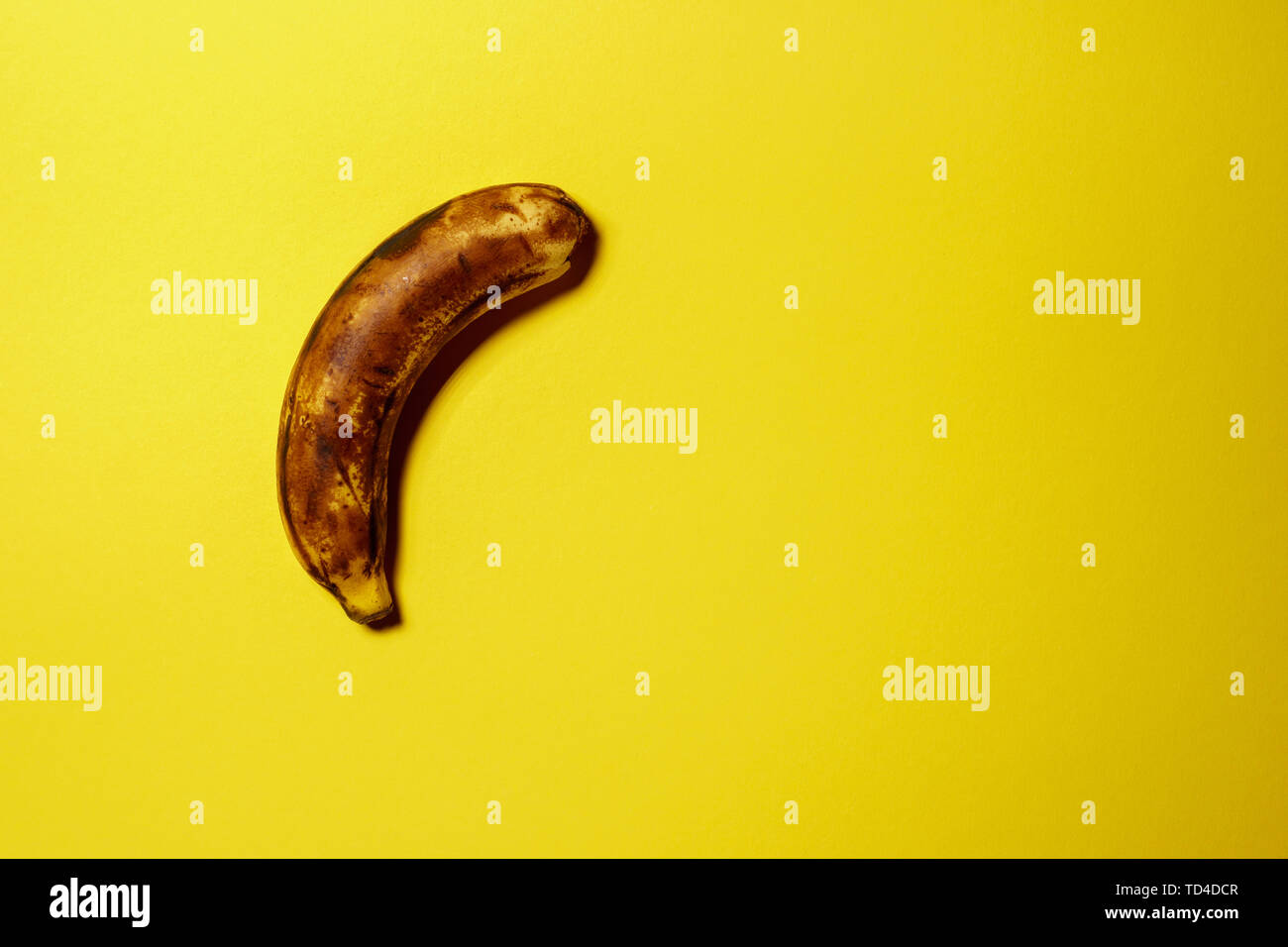 Single old rotten banana isolated on yellow background Stock Photo - Alamy
