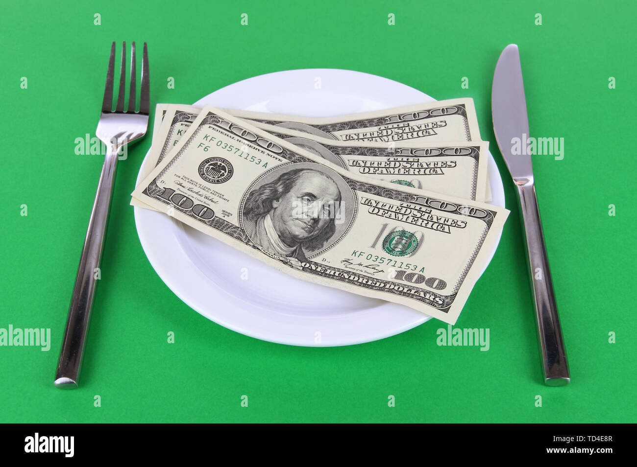 Money on plate on green background Stock Photo - Alamy