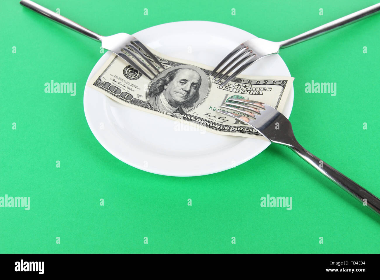 Money on plate on green background Stock Photo - Alamy