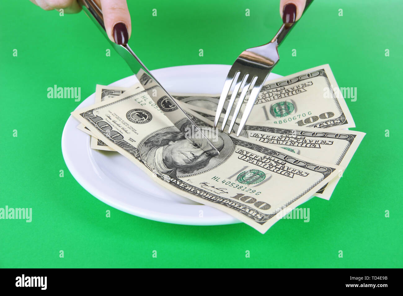 Money on plate on green background Stock Photo - Alamy