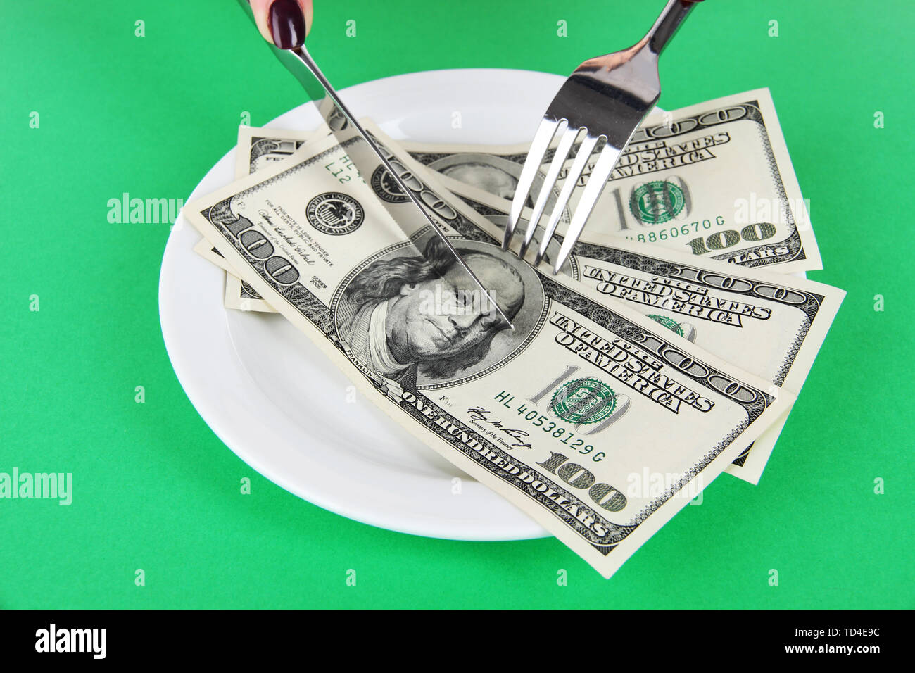 Money on plate on green background Stock Photo - Alamy