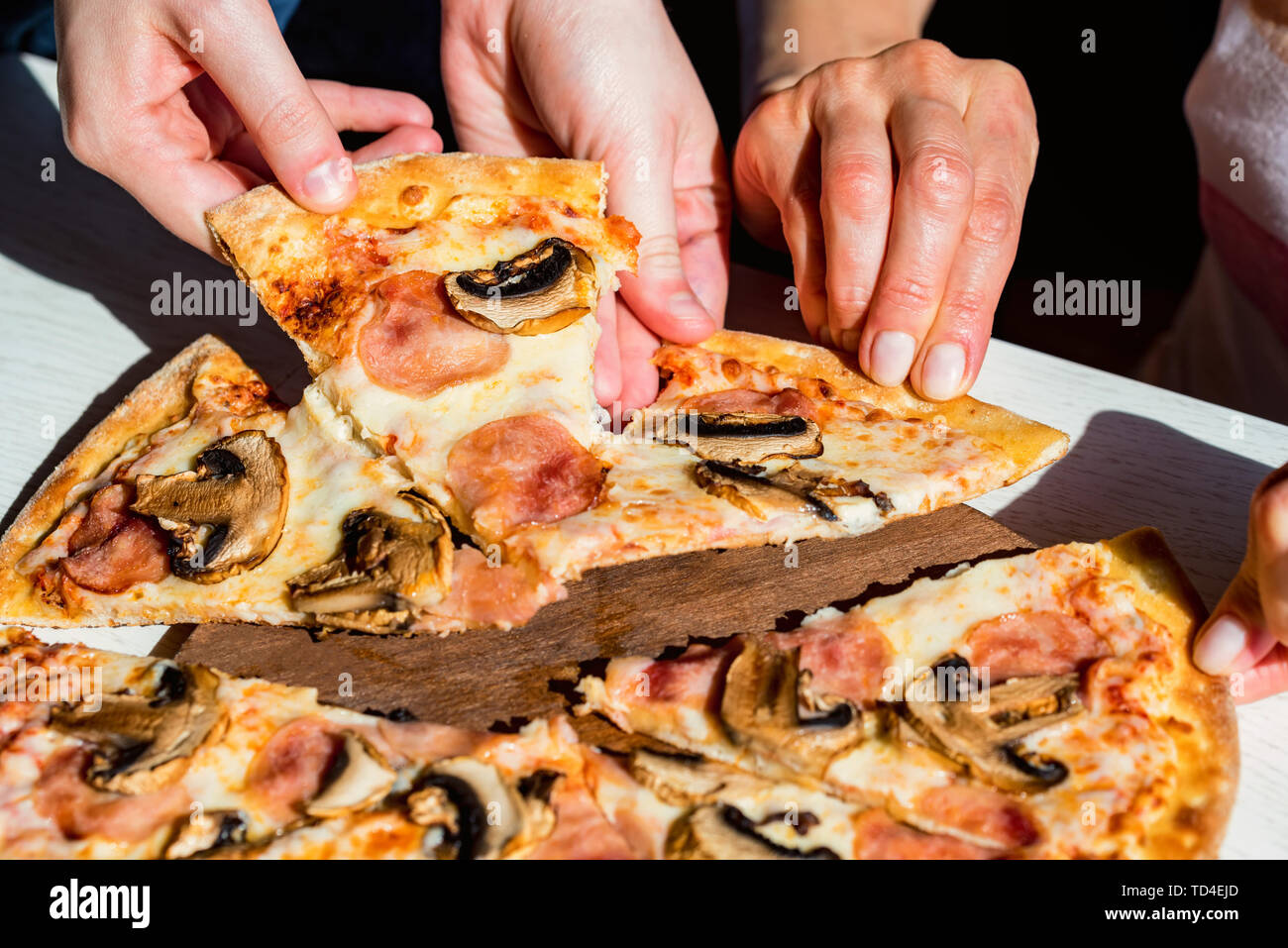 Hands take slices of pizza hi-res stock photography and images - Alamy