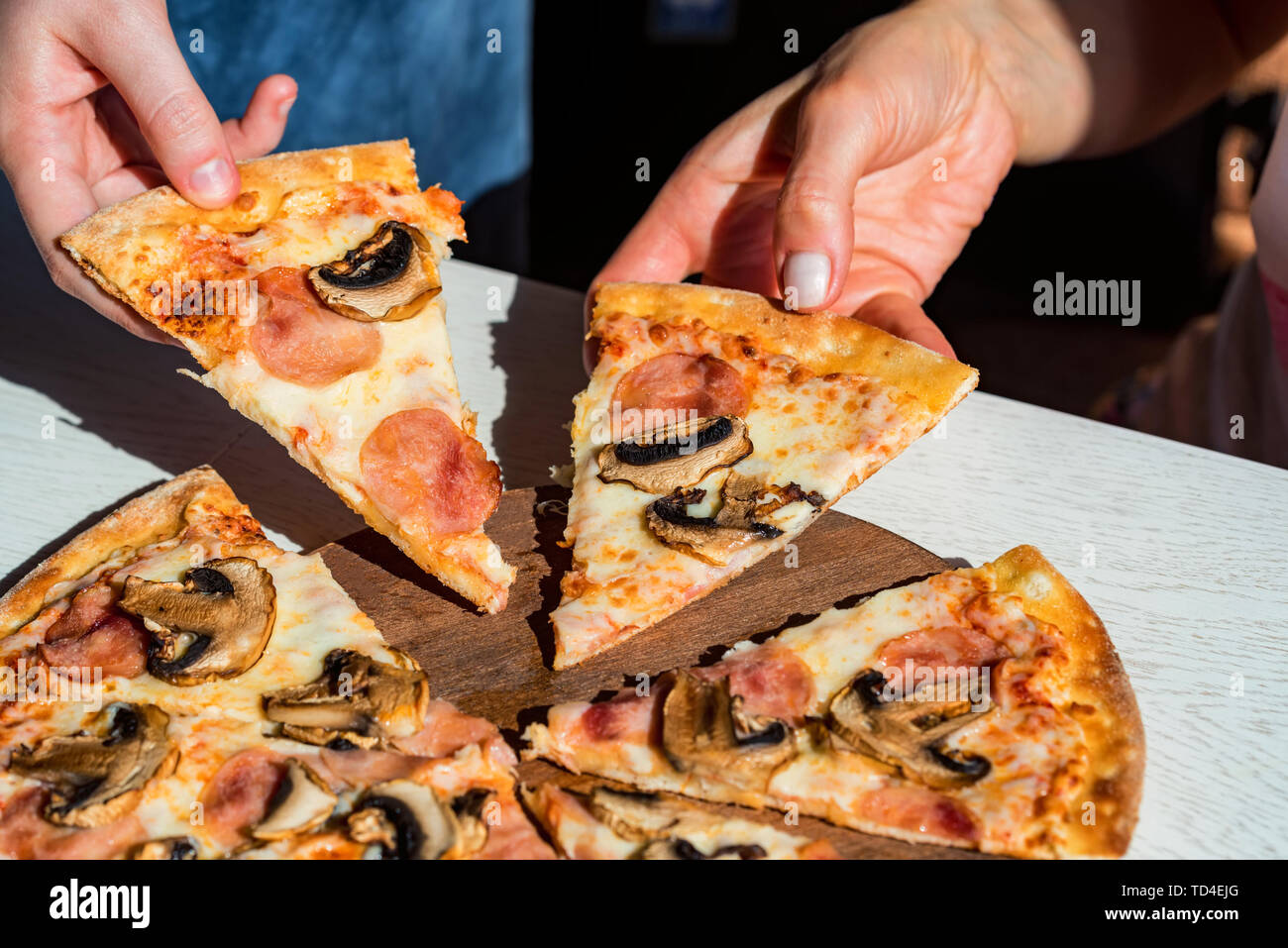 Hands take slices of pizza hi-res stock photography and images - Alamy