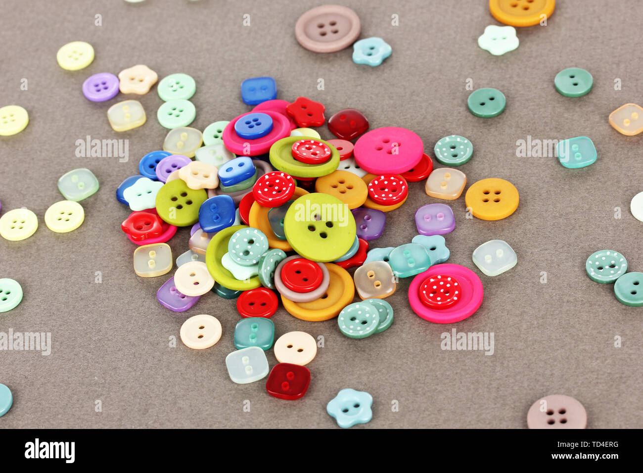 Buttons of different shapes, sizes and colors close-up on gray ...