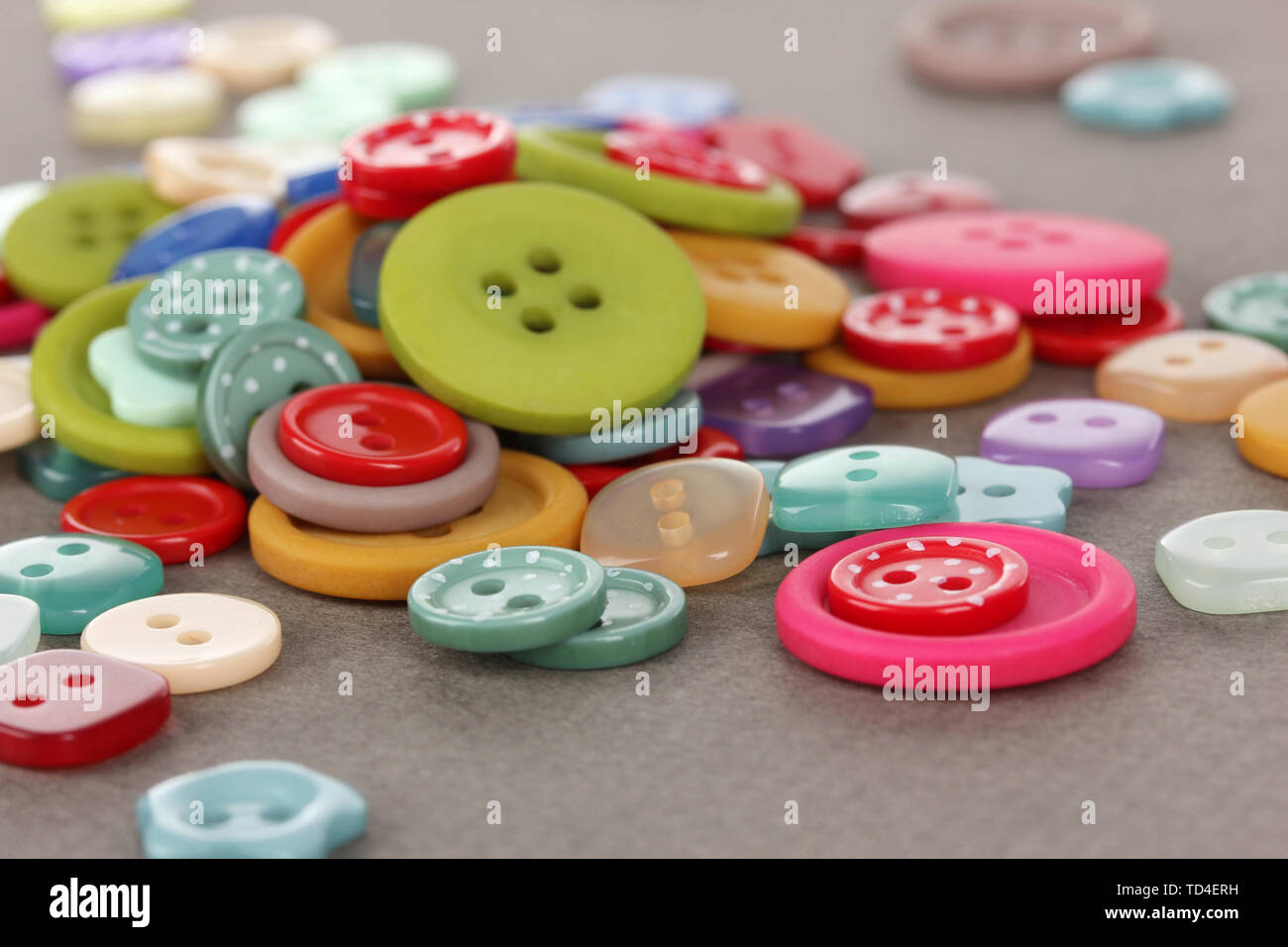 Buttons of different shapes, sizes and colors close-up on gray ...