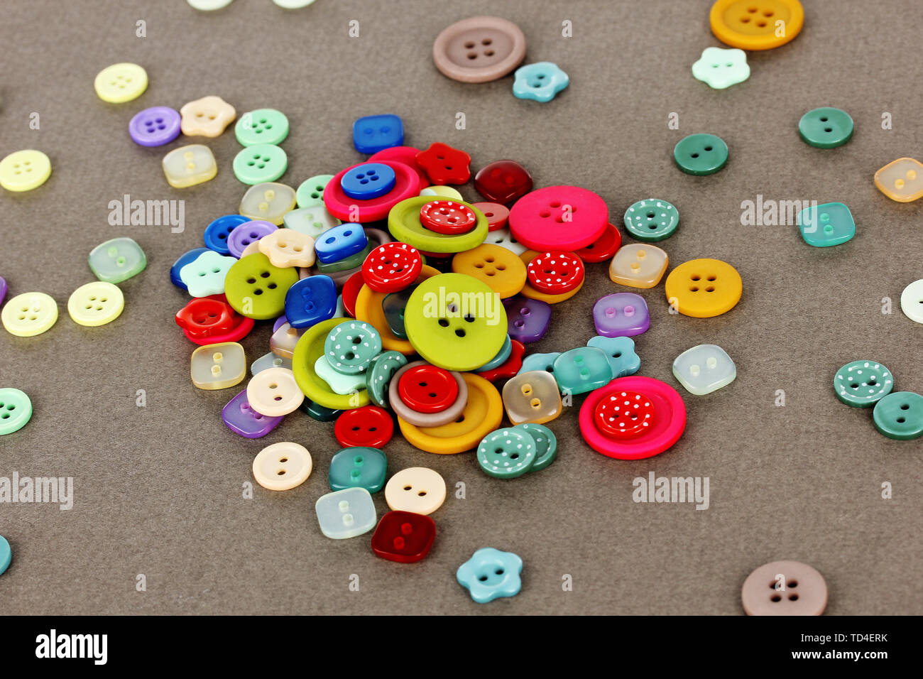Buttons of different shapes, sizes and colors close-up on gray ...