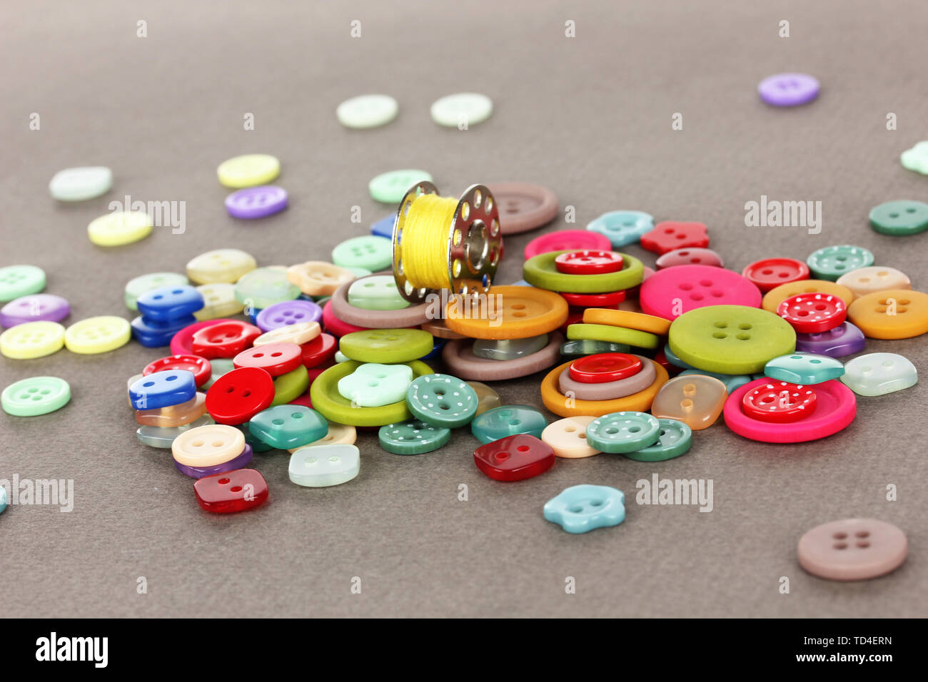 Buttons of different shapes, sizes and colors close-up on gray ...