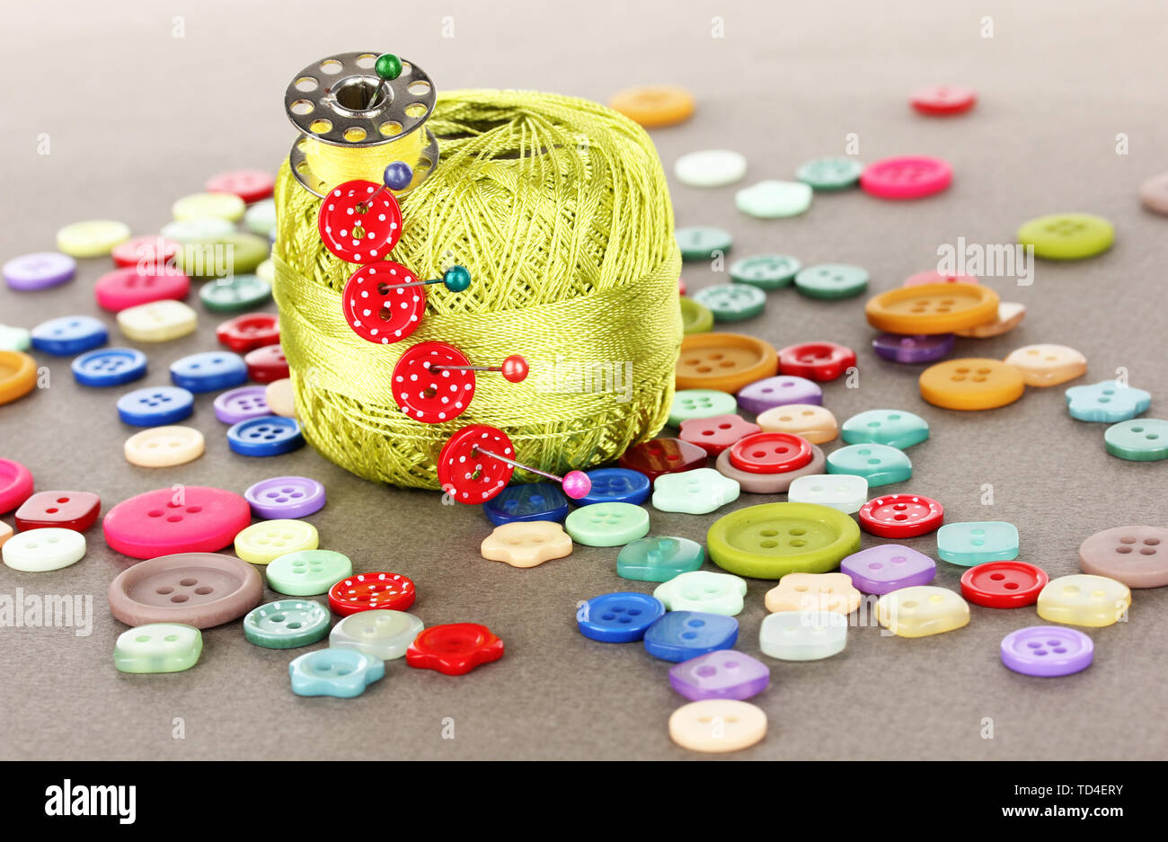 Buttons of different shapes, sizes and colors close-up on gray ...