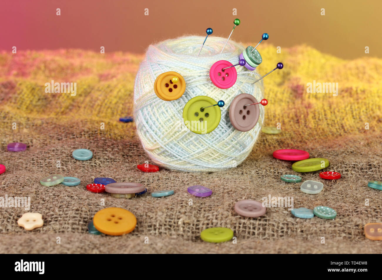 Ball of thread in the buttons on a colorful background Stock Photo - Alamy