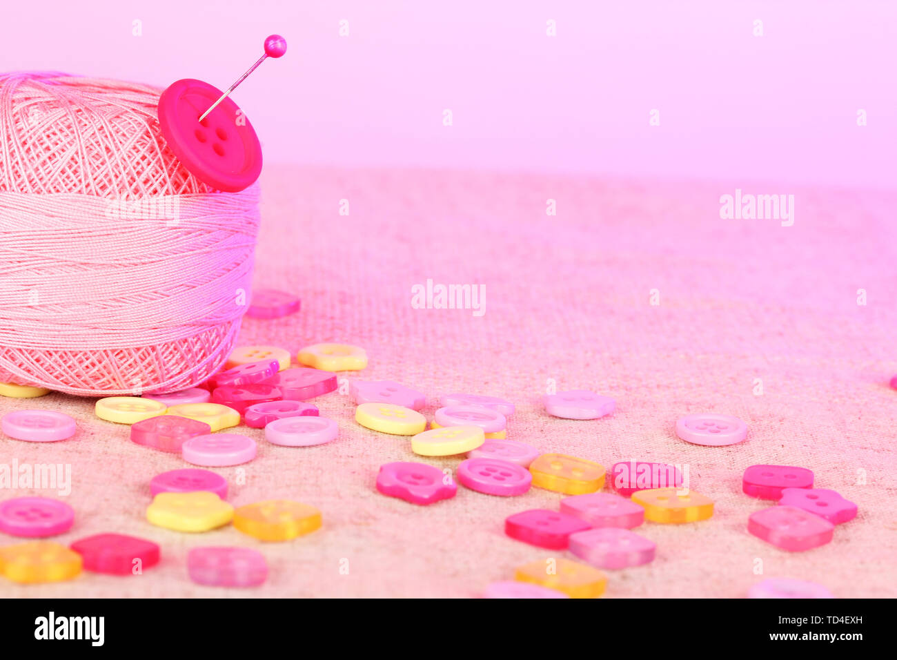 Beautiful buttons and a ball of yarn on a pink background Stock Photo ...