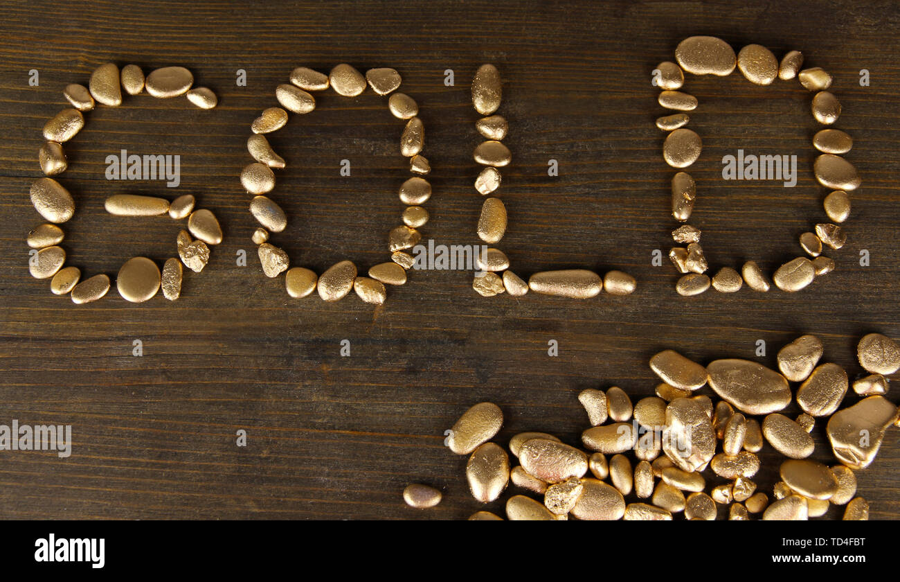 Word gold making with golden stones on wooden background Stock Photo ...