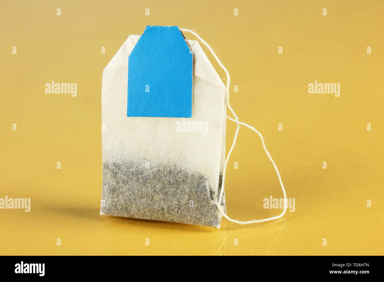 Tea bag on yellow background Stock Photo - Alamy