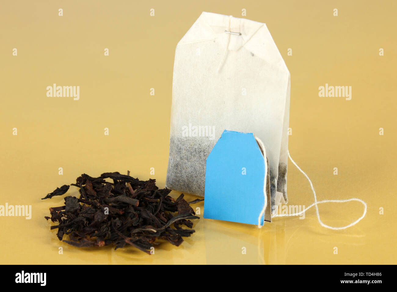 Tea bag on yellow background Stock Photo - Alamy