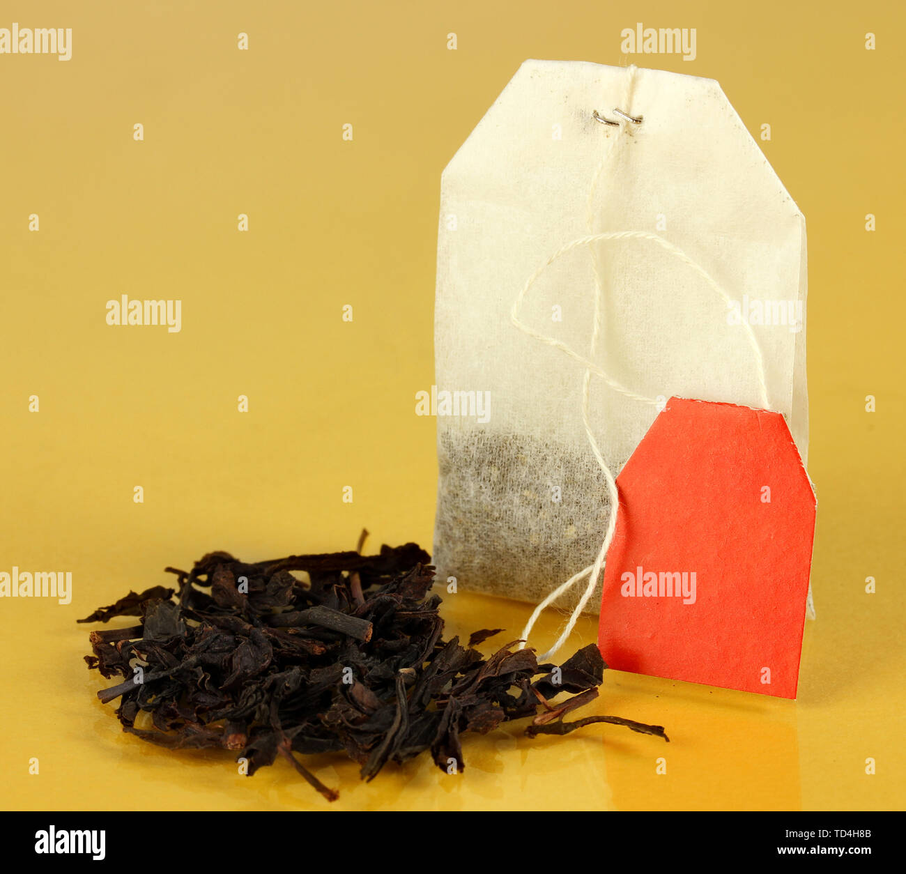 Tea bag on yellow background Stock Photo - Alamy