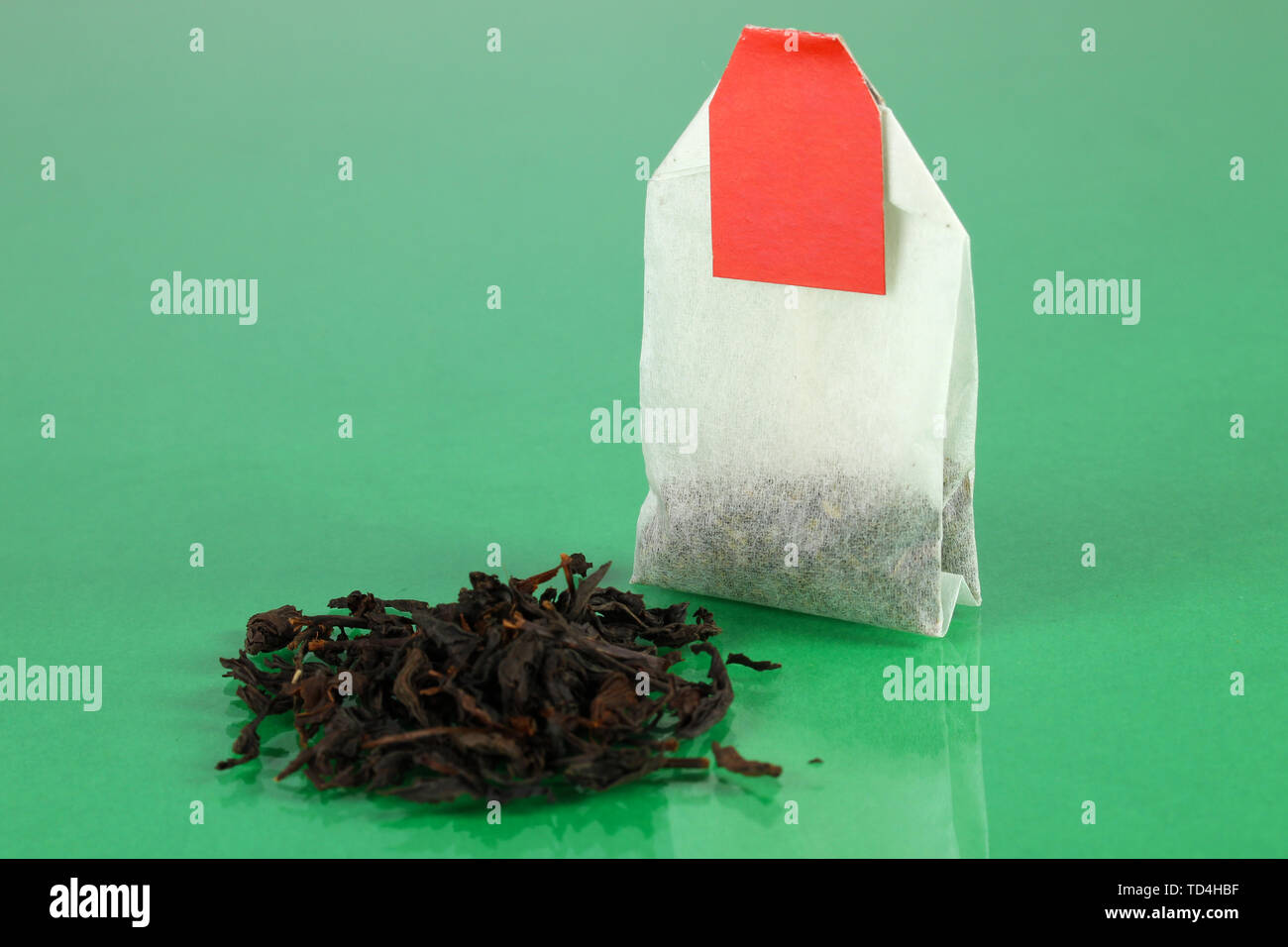 Tea bag on green background Stock Photo - Alamy