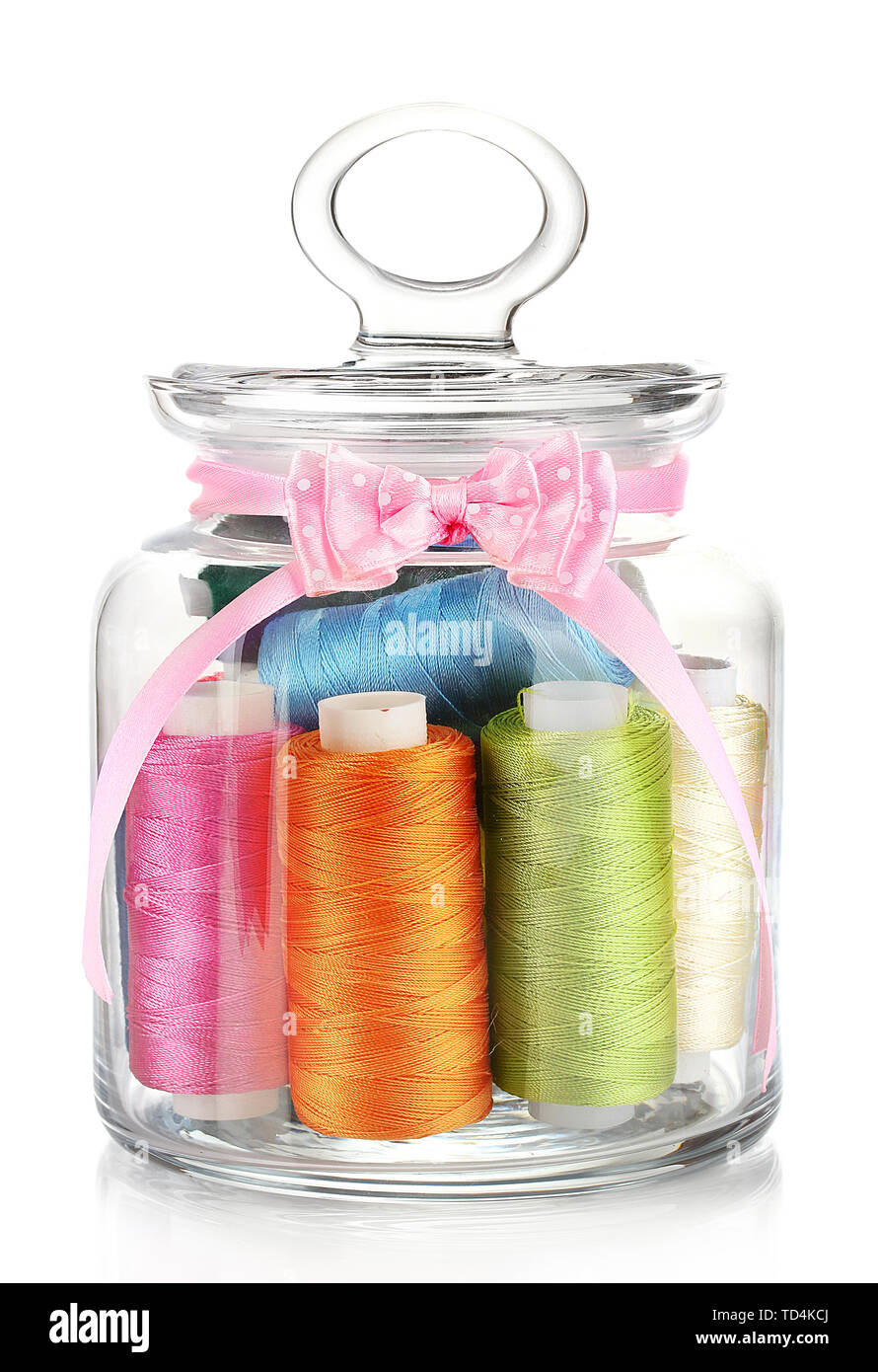 Glass jar containing various colored thread isolated on white Stock ...