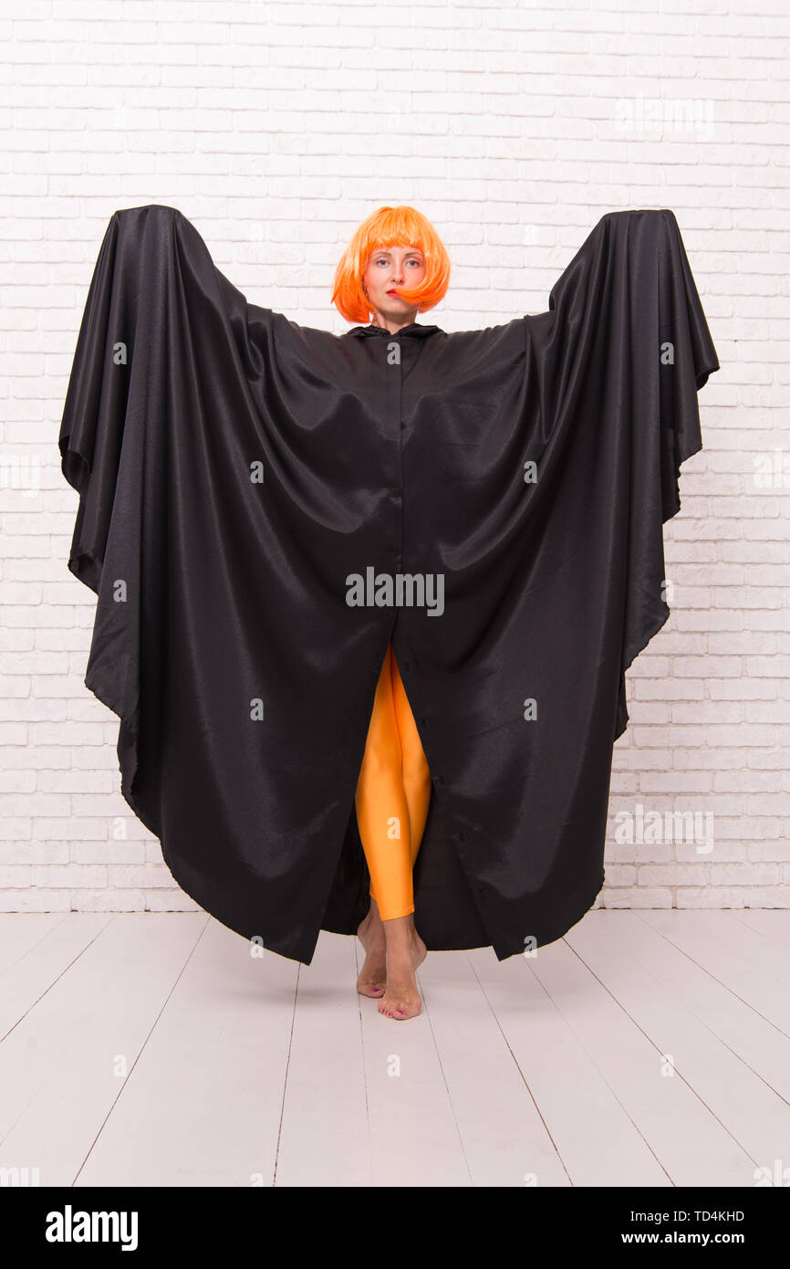 Dancing in cloak. Girl with long fit legs in orange tights dancing ...