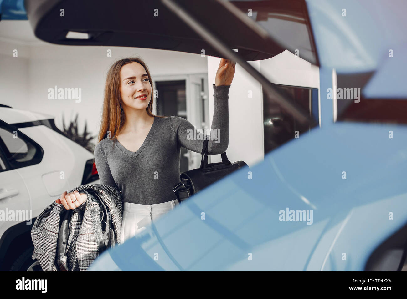 Woman buying the car. Lady in a car salon Stock Photo - Alamy