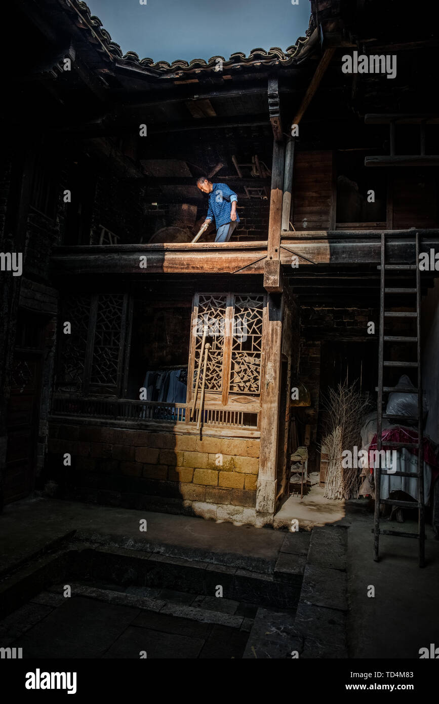 The old man sweeping the floor in the attic Stock Photo - Alamy