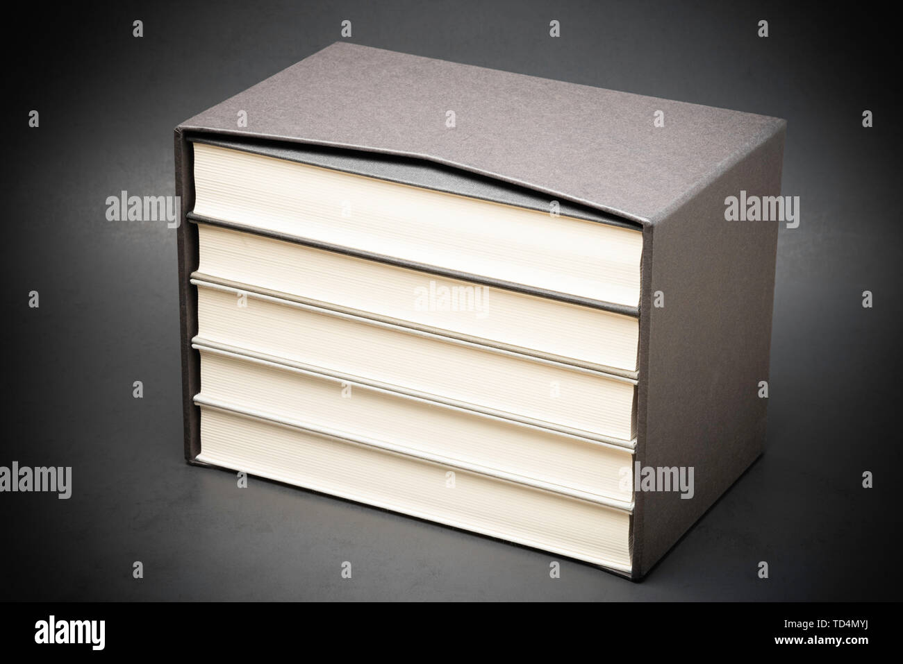 A set of five monochromatic cloth-bound books inside a black hard ...