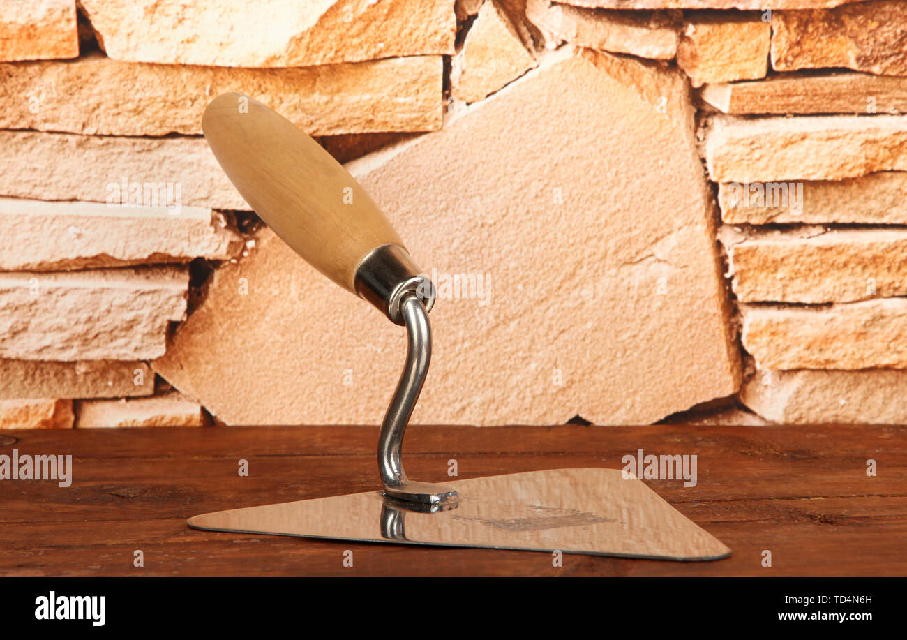 Metal tool for building on brick wall background Stock Photo - Alamy