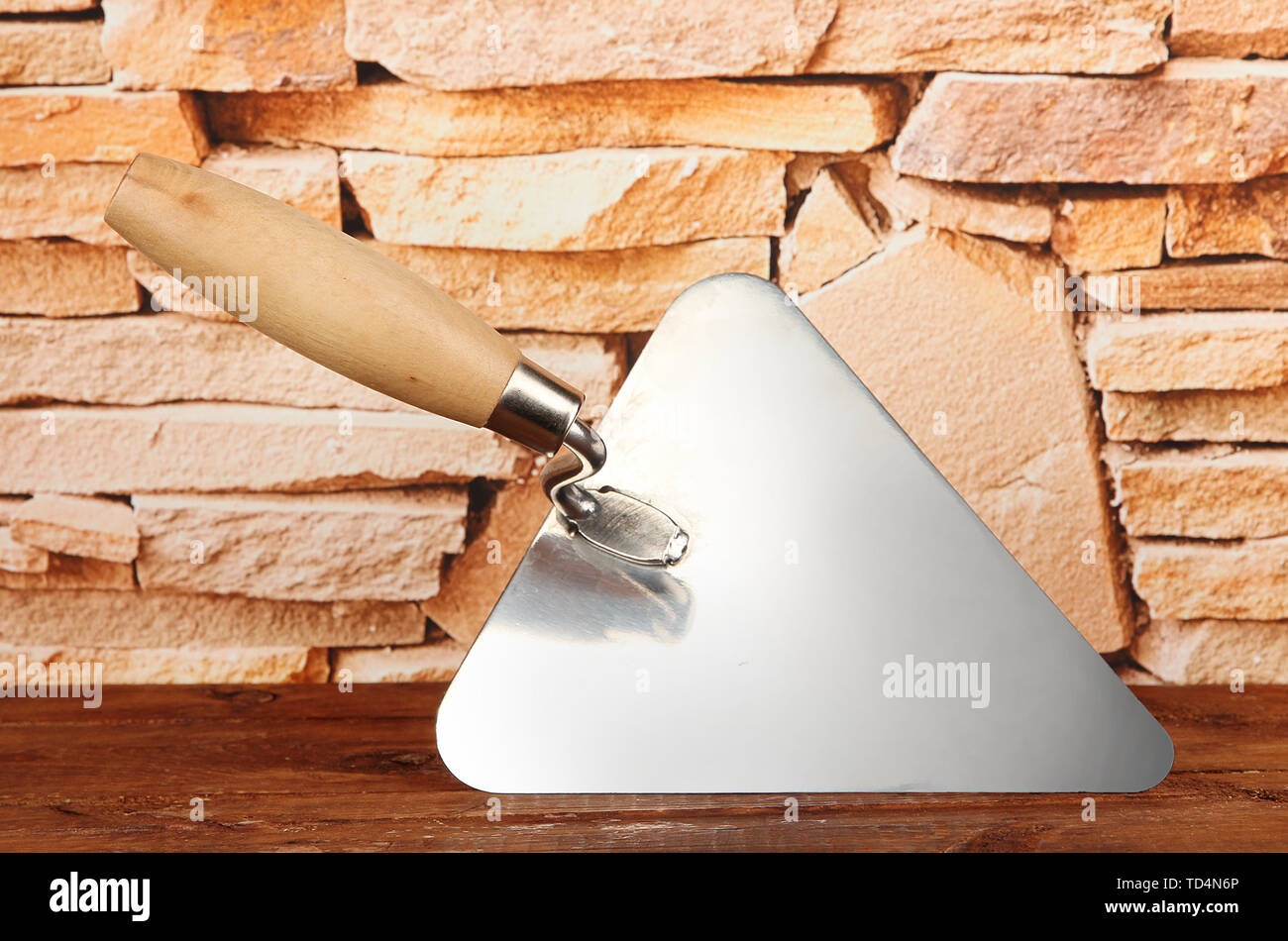 Metal tool for building on brick wall background Stock Photo - Alamy