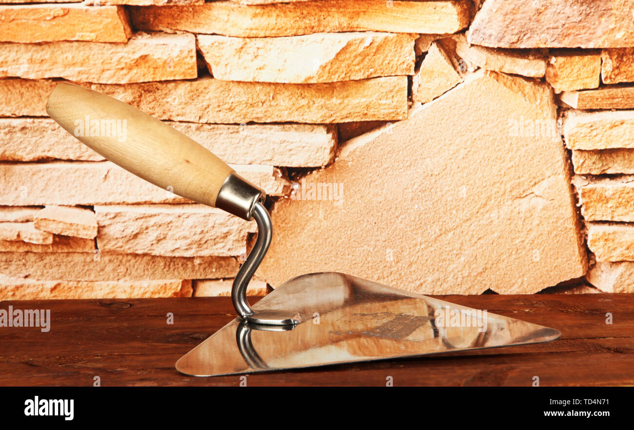 Metal tool for building on brick wall background Stock Photo - Alamy