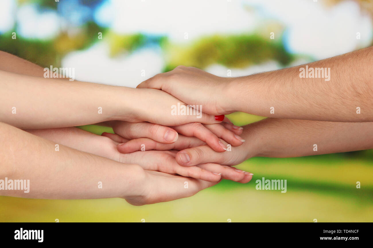 Many hands on nature background Stock Photo - Alamy