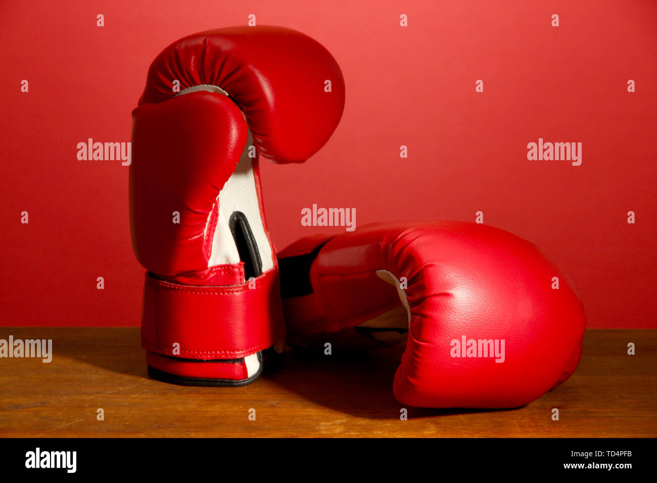Boxing gloves on wooden table, on red background Stock Photo - Alamy