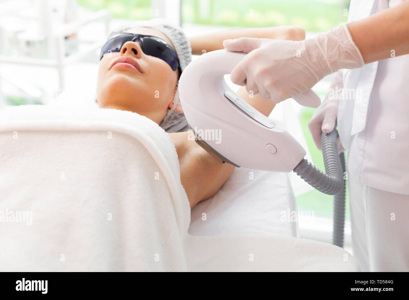 Professional cosmetologist doing arm laser hi-res stock photography and ...
