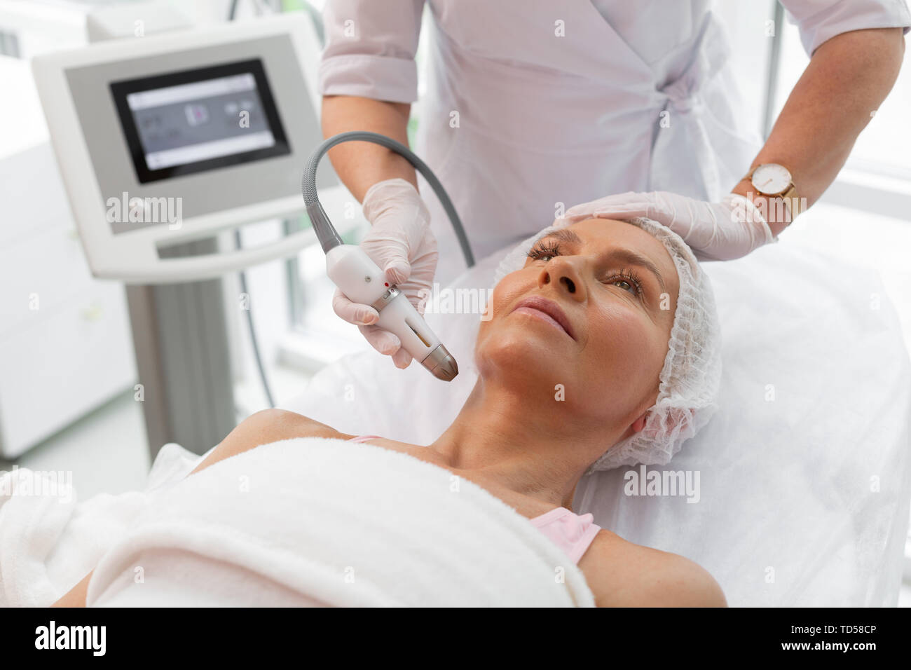 Neck contour. Nice good looking woman having a lifting procedure while ...