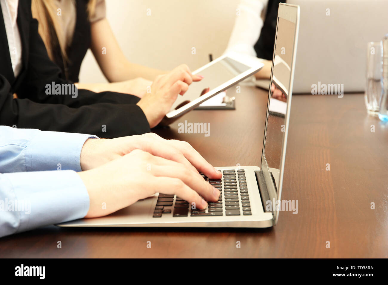 Male hands with laptop on office background Stock Photo - Alamy