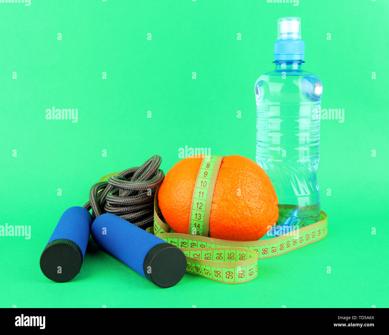Orange with measuring tape,skipping rope and bottle of water, on color ...