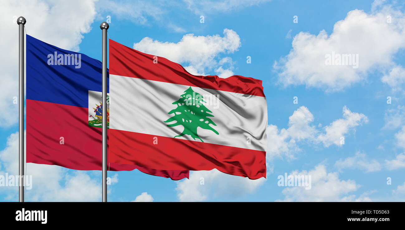 Haiti and Lebanon flag waving in the wind against white cloudy blue sky ...