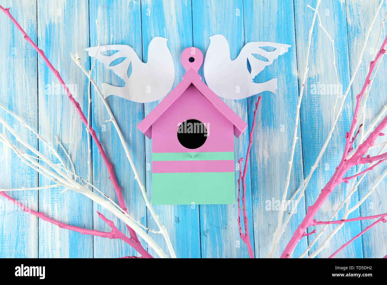 Decorative nesting box with paper birds and color branches, on color ...