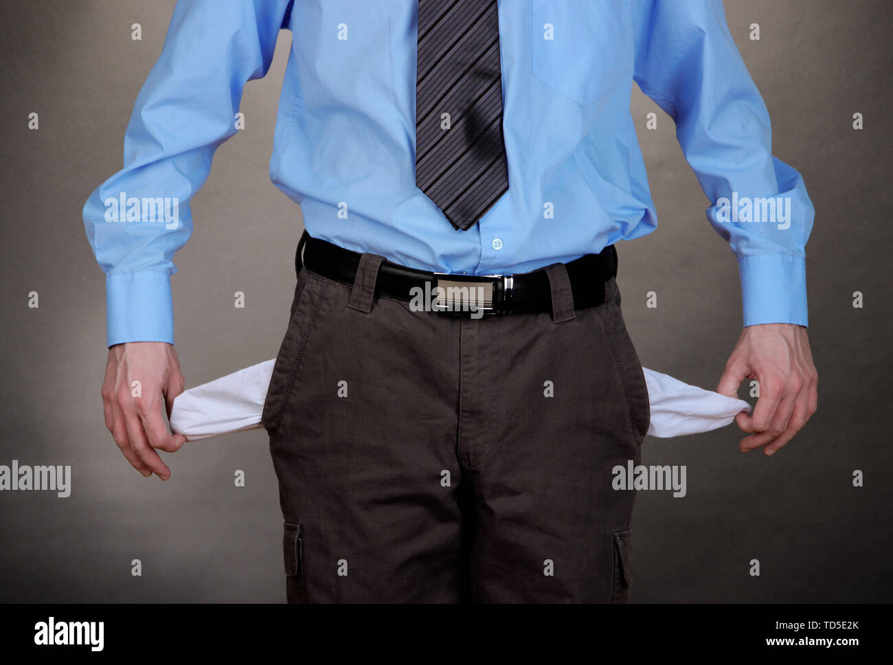 Business man showing his empty pockets, on grey background Stock Photo ...