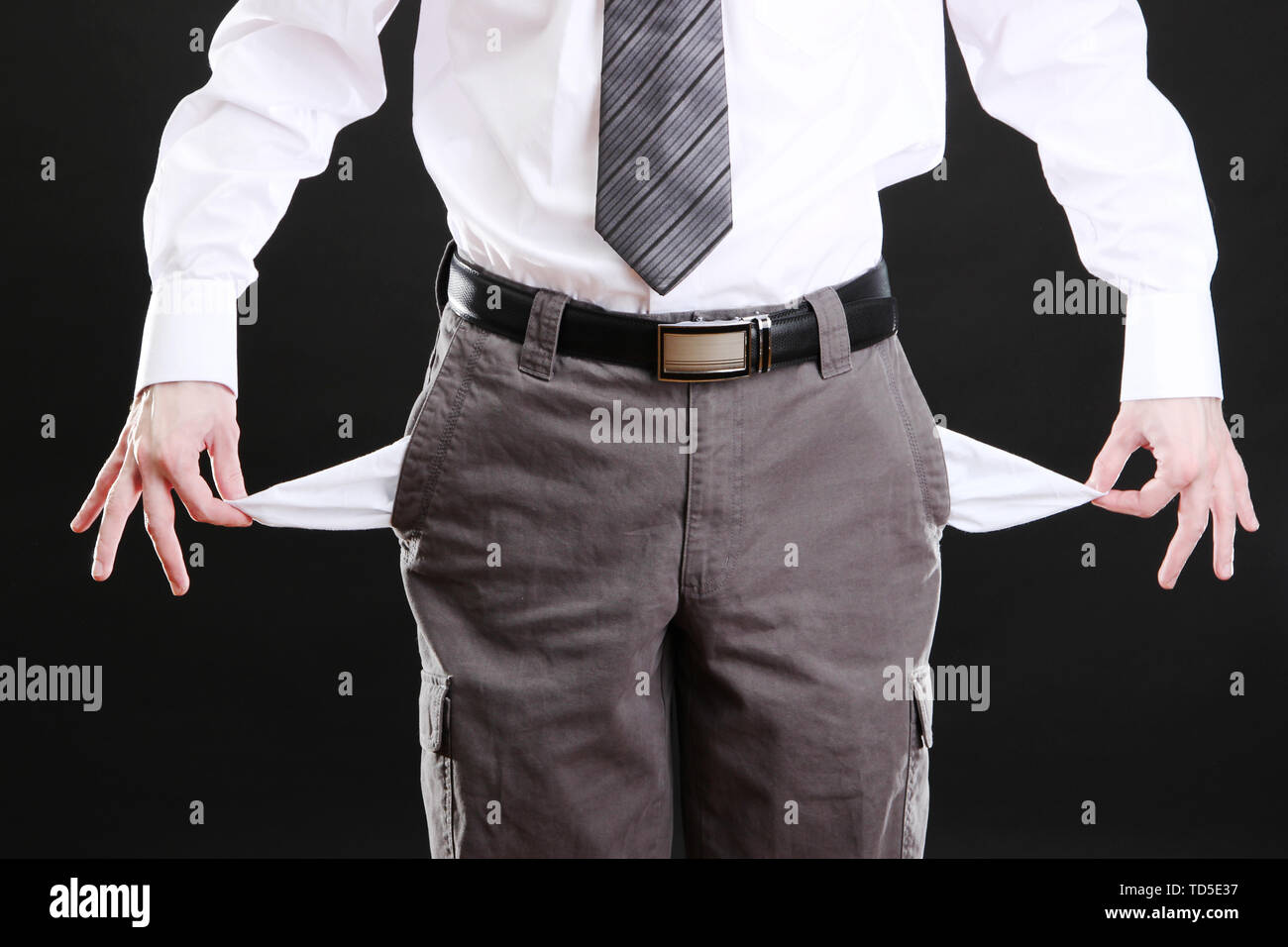 Business man showing his empty pockets, on black background Stock Photo ...